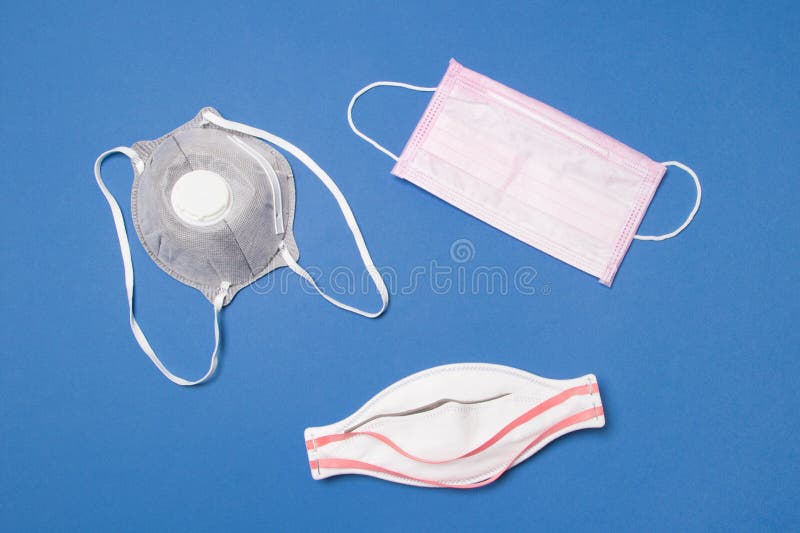 Protective Medical Face Masks on Blue Colored Paper Background Stock ...