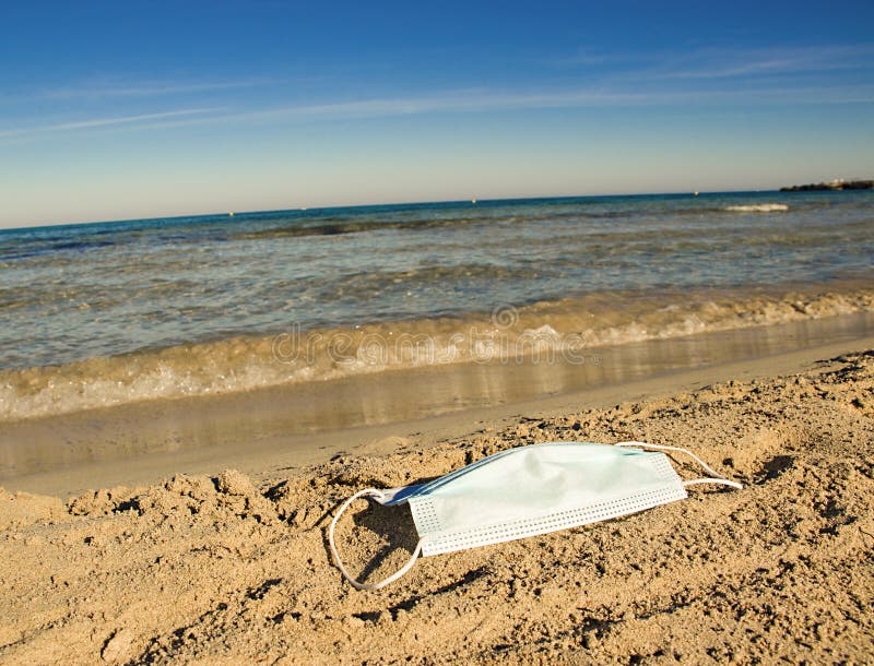 A Protective Medical Mask is Lying on the Sand on the Beach ...