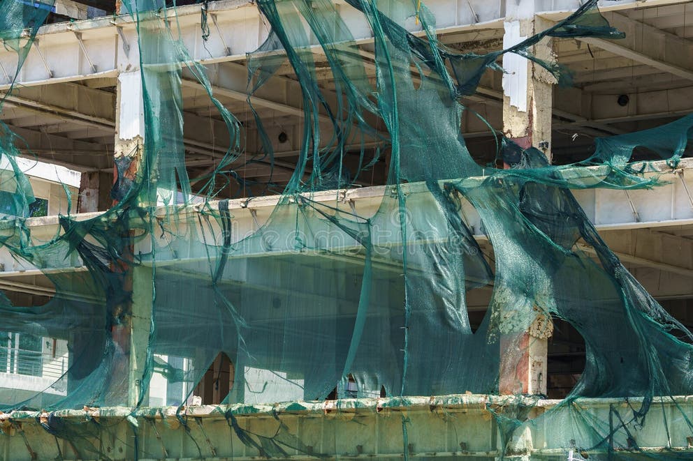 Protective Mesh on Scaffolding Torn by Hurricane Wind. Background with ...