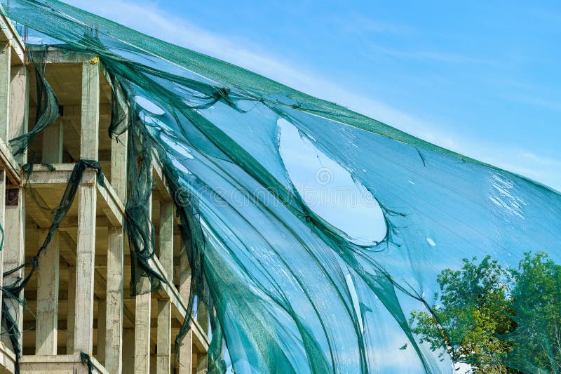 Protective Mesh on Scaffolding Torn by Hurricane Wind. Background with ...