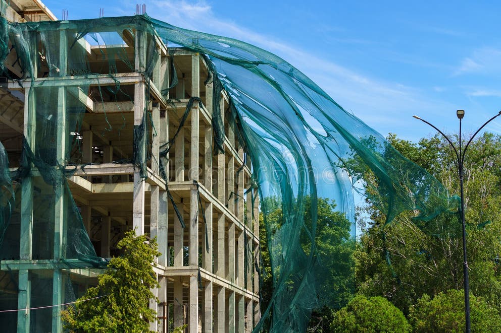 Protective Mesh on Scaffolding Torn by Hurricane Wind. Background with ...