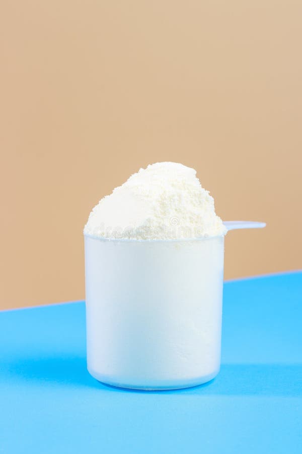 Protein Powder in Scoop Close-up on Blue and Brown Background. Stock ...
