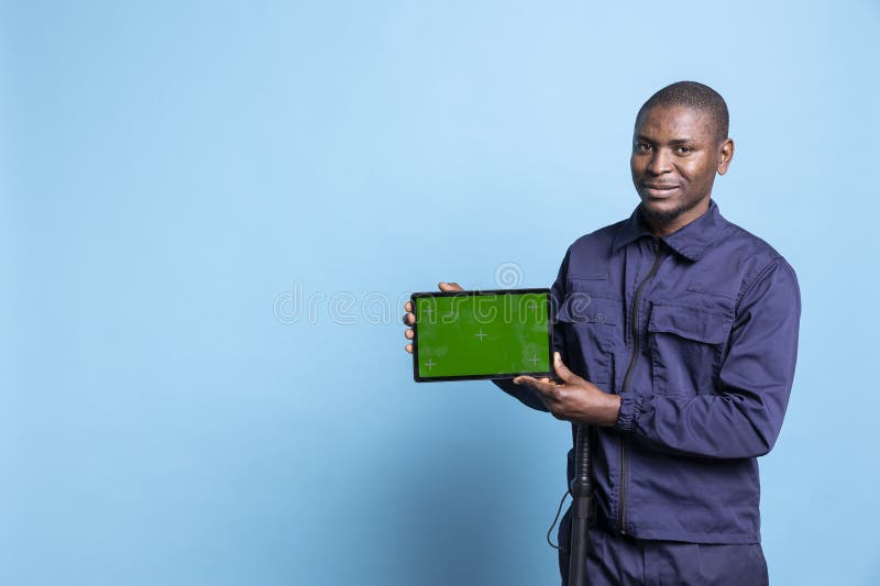 Proud Security Guard in Uniform Holds a Tablet with Greenscreen on ...