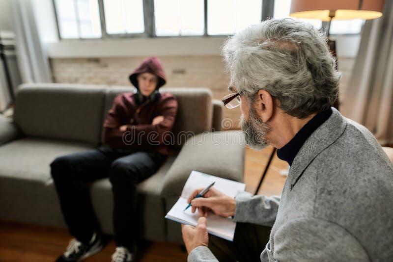 Psychoanalyst Taking Notes during Appointment with Uneasy Teenage Boy ...