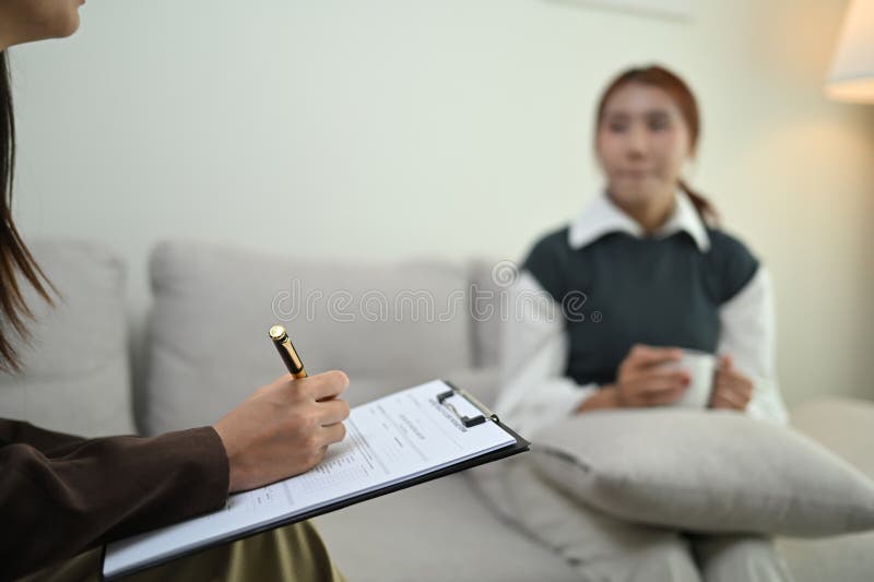 Psychologist Taking Detailed Notes while Talking with Patient during ...