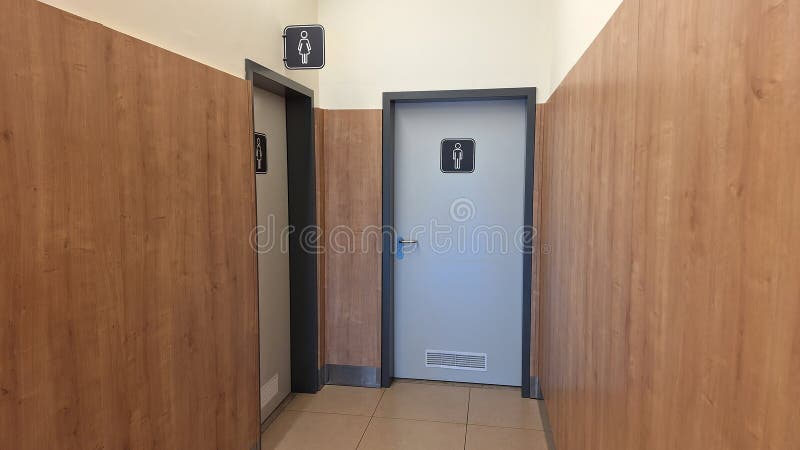 Public Restroom Entrance in Modern Facility with Light Wood Paneling ...