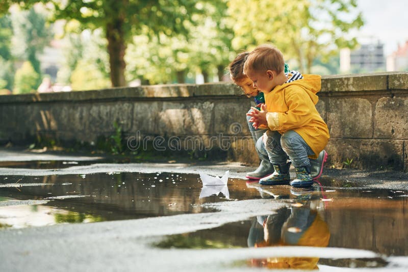 In the Puddle. Kids Having Fun Outdoors in the Park after the Rain ...