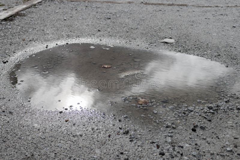 Puddle on the Road, Reflecting the Clouds. Stock Image - Image of water ...
