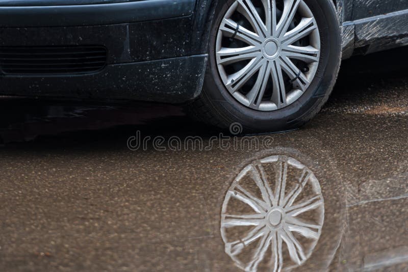 Puddle on the Pavement with a Reflection of the Car Wheel, Closeup ...