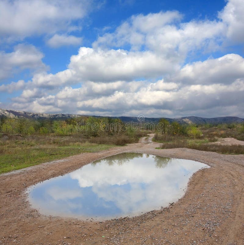Puddle on road after rain stock photo. Image of gravel - 11650064