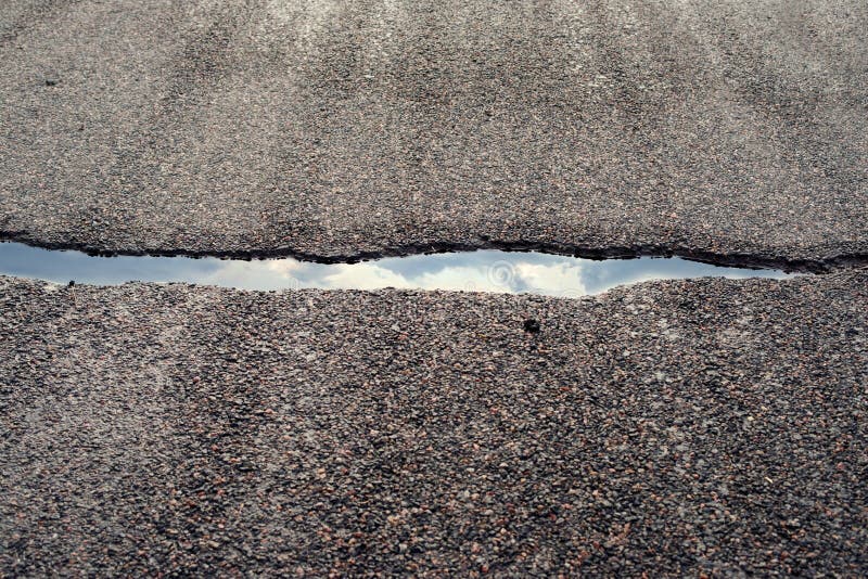 Puddle with Sky Reflection in Crack on Highway Asphalt Stock Photo ...