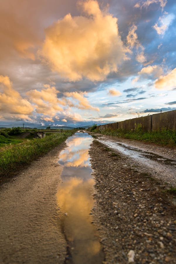 Puddle in sunset colors stock photo. Image of rain, landscape - 96792750