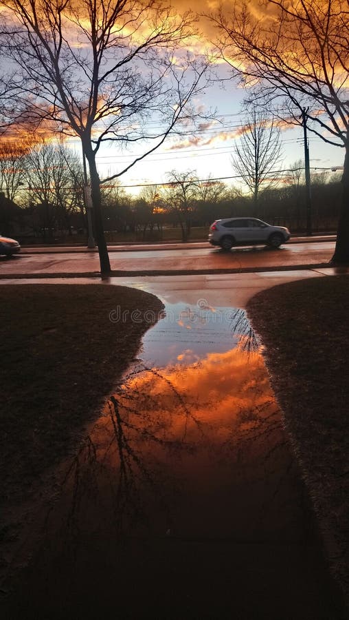 Puddle sunset reflections stock image. Image of road - 138133697