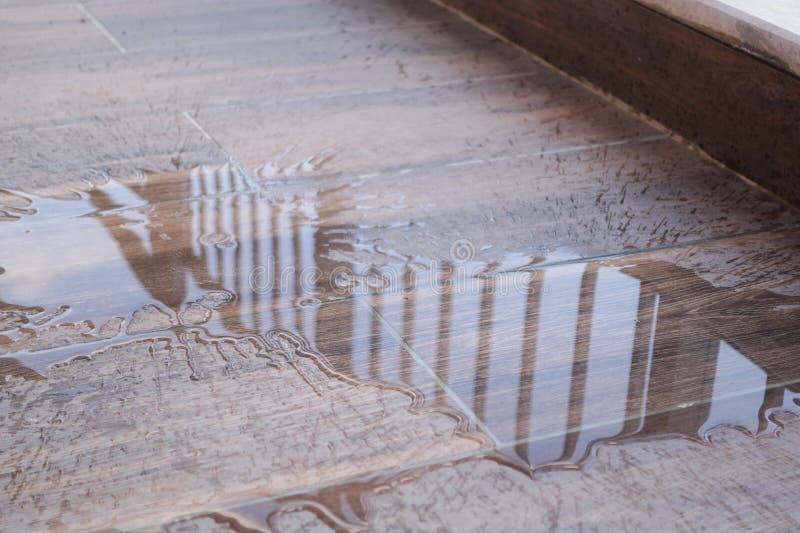A Puddle of Water on a Tiled Surface Showcases Reflections Stock Photo ...