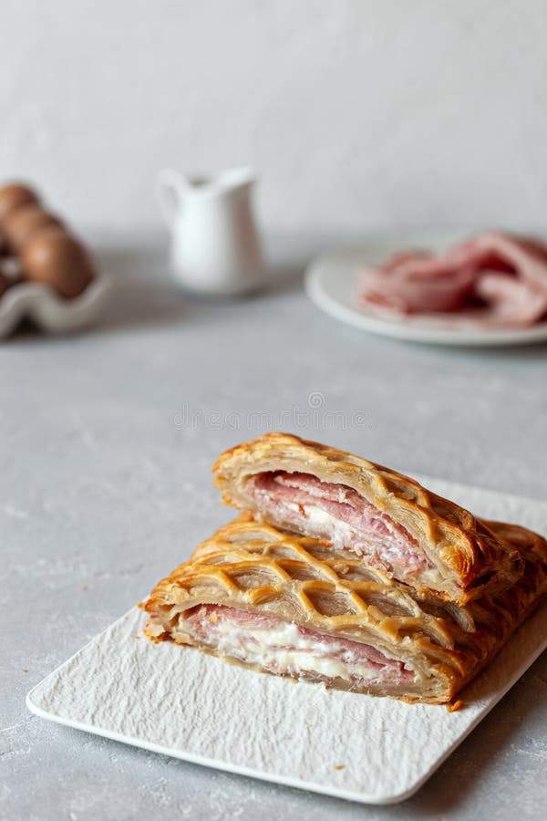 Puff with Ham and Cheese Cut on a Rectangular Plate on a Kitchen Table ...