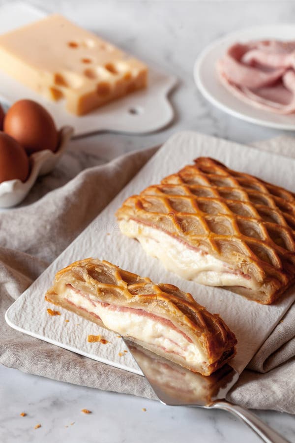 Puff with Ham and Cheese Cut on a Rectangular Plate on a Kitchen Table ...