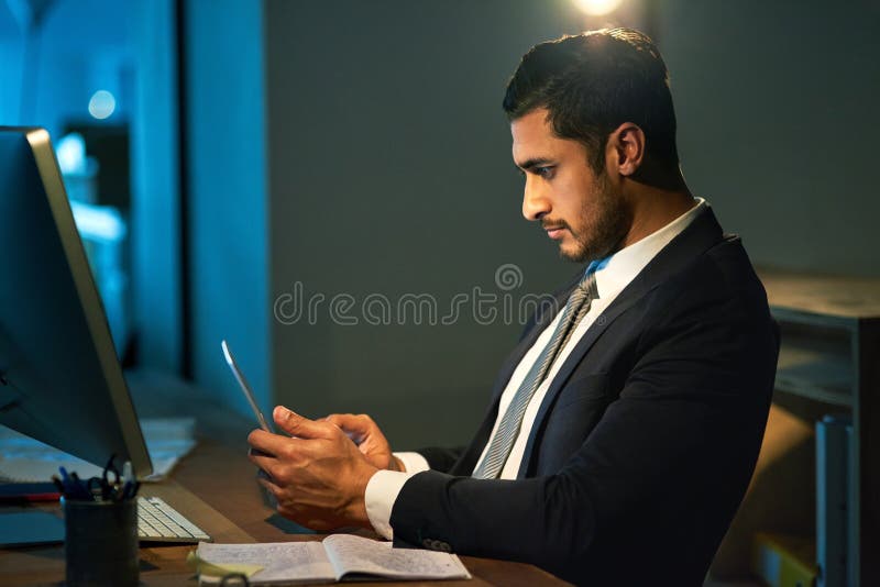 Pulling an All Nighter. a Young Businessman Using a Digital Tablet ...