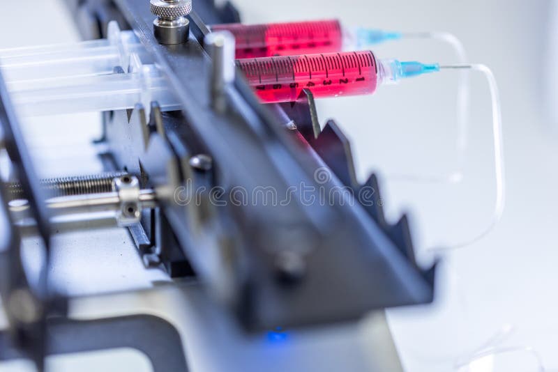 Pump Pushing Red Liquid Medium through Syringes and Flexible Tubes in a ...