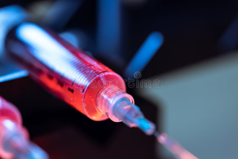 Pump Pushing Red Liquid Medium through Syringes and Flexible Tubes in a ...