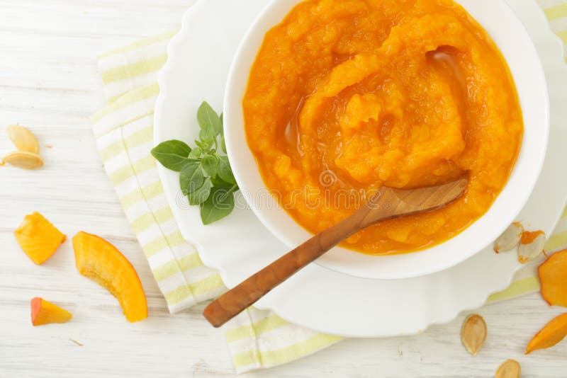 Pumpkin Puree in a Plate of Pumpkin Slices on a White Table Stock Photo ...