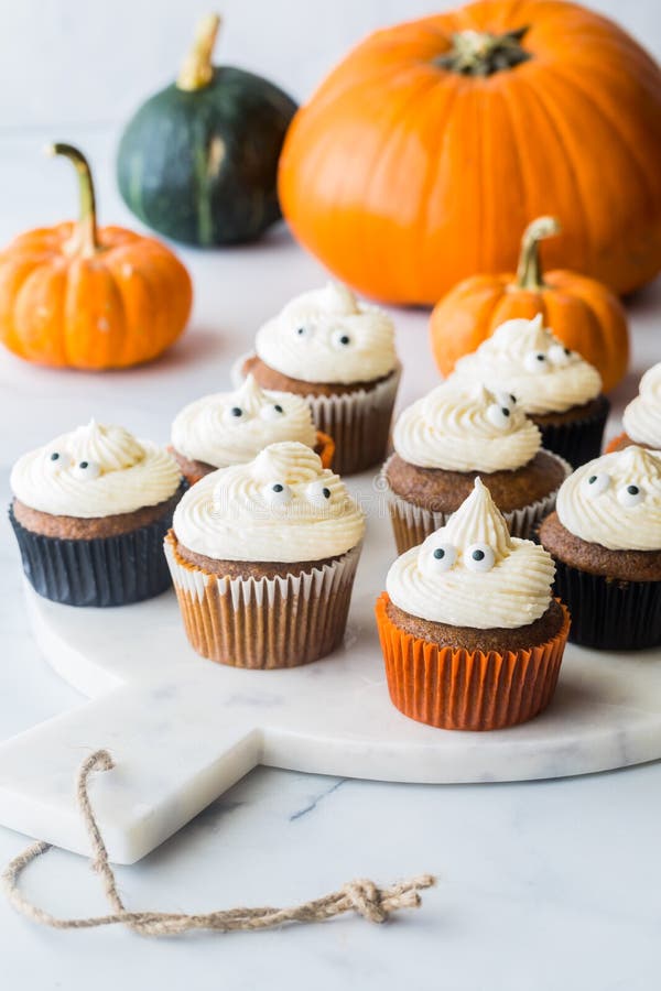 Pumpkin Spice Cupcakes on a Marble Slap with Fresh Whole Pumpkins in ...