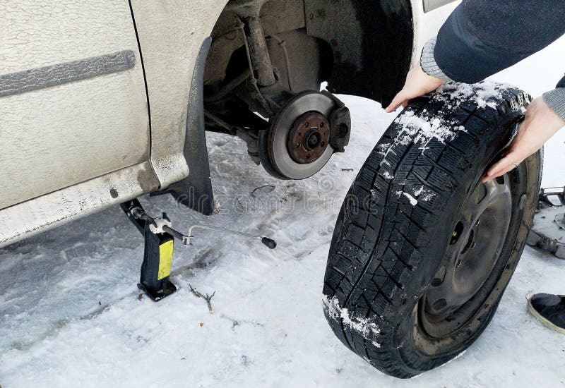 Punched and Flat Tire on the Road. Replacing the Wheel with a Jack by ...