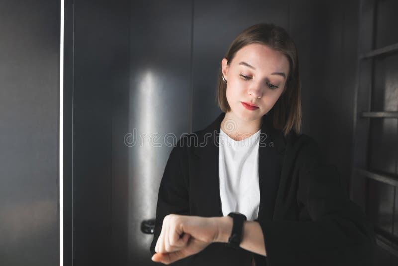 Punctual Office Worker is Checking Time in the Lift. Young Woman is ...
