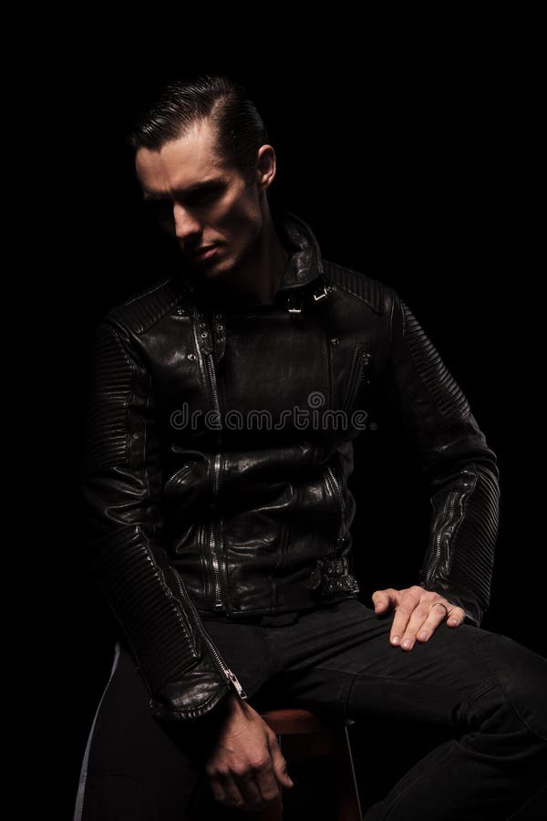 Punk Model in Leather Jacket Posing Seated in Dark Studio Stock Photo ...