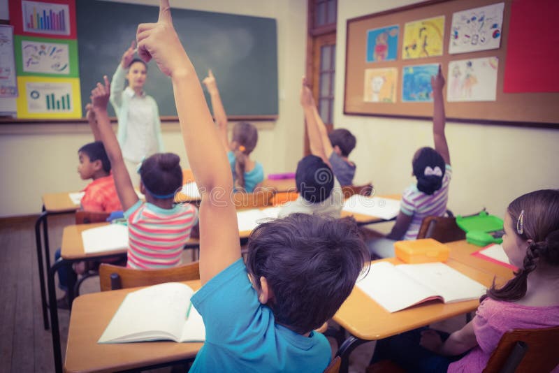 Elementary School Kids in a Classroom Raising Their Hands Stock Photo ...