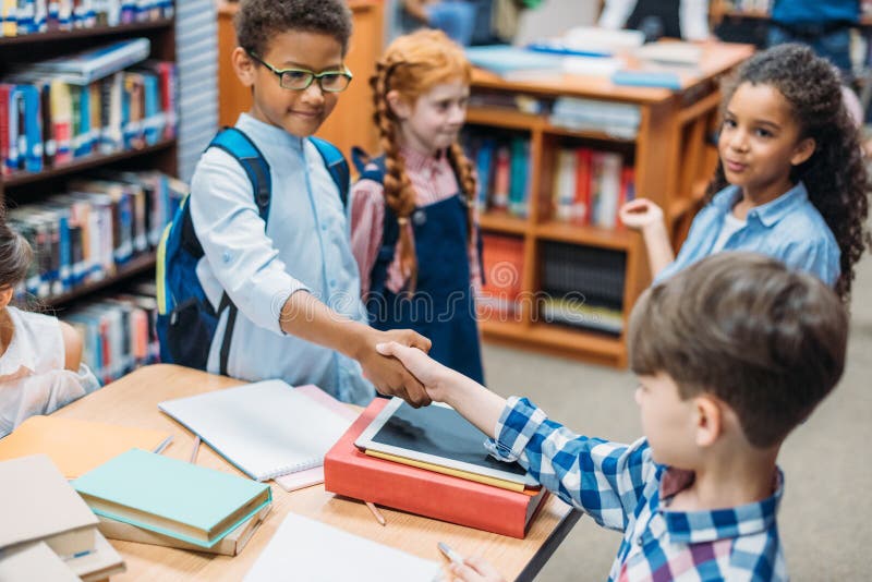 Pupils shaking hands stock image. Image of children - 129168573