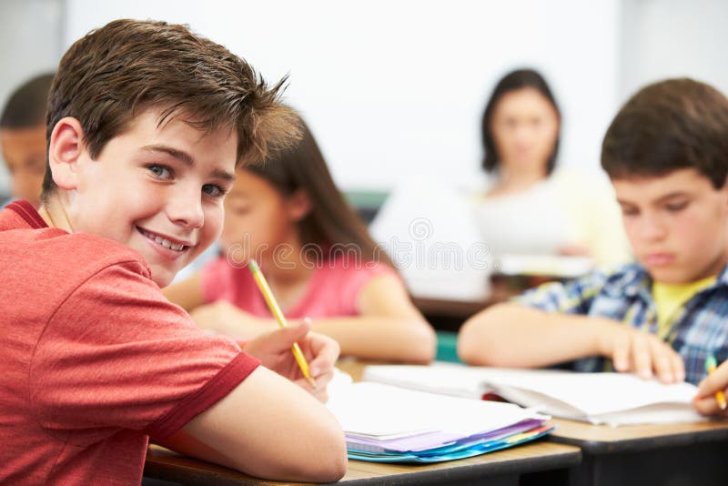 Pupils Studying at Desks in Classroom Stock Image - Image of male ...