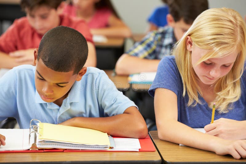 Pupils Studying at Desks in Classroom Stock Image - Image of classroom ...