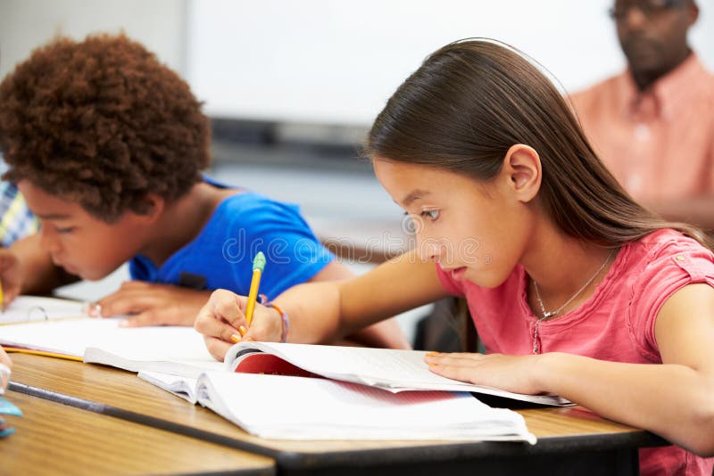 Pupils Studying at Desks in Classroom Stock Photo - Image of class ...