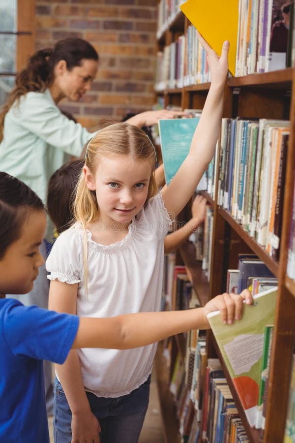 Pupils Taking Books from Shelf in Library Stock Photo - Image of female ...