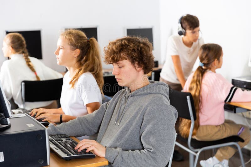 Pupils Using Computers at Lesson, Teacher Teaching Them in Class Room ... Pupils Using Computers at Lesson, Teacher Teaching Them in Class Room ...