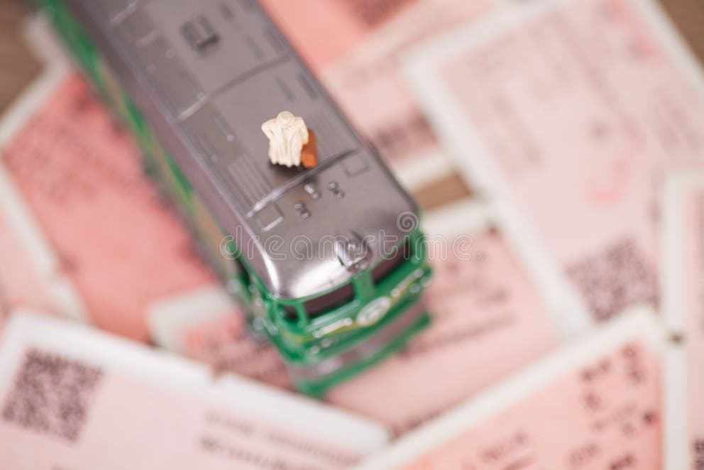 A Puppet Model Stands on a Train Model and a Pile of Train Tickets ...
