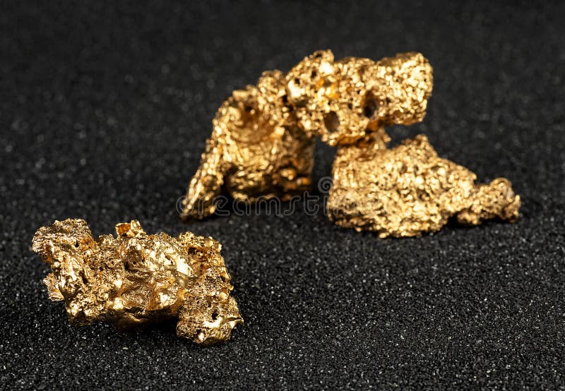 Pure Gold Nuggets from the Mine on Black Sand. Gold Ore Stock Photo ...