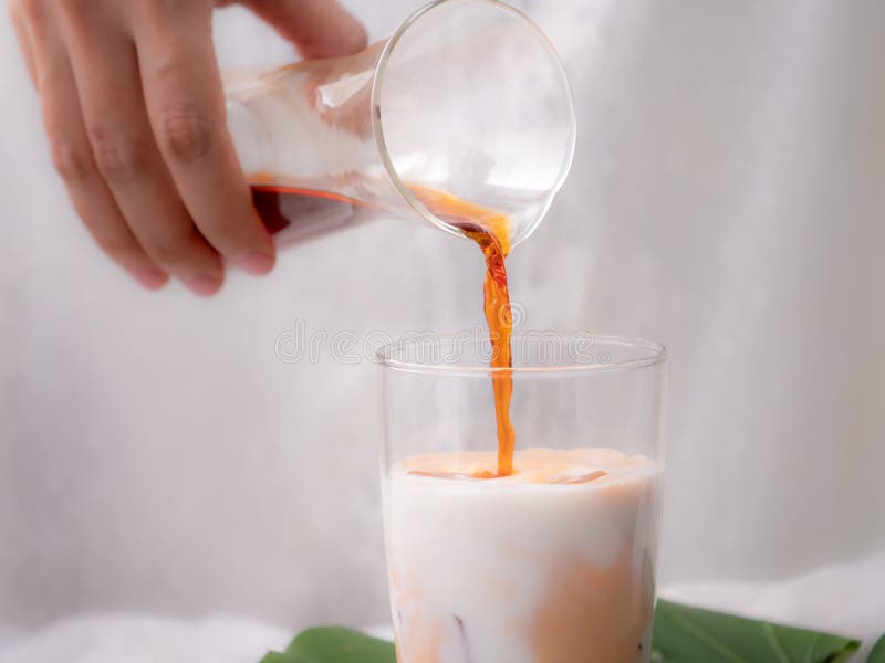 Puring tea in milk glass stock photo. Image of hand - 146405924