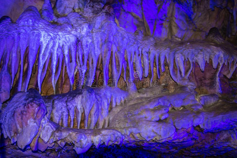 Purple Light Shining on Icicle Like Forms in a Cave. Stock Photo ...