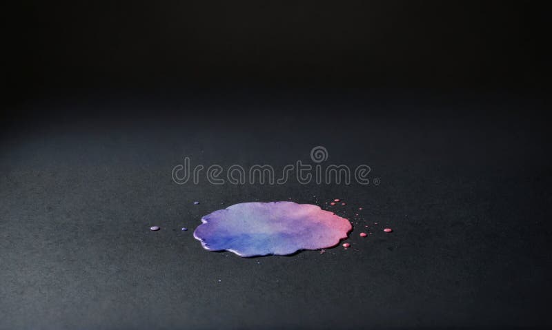 A Purple and Pink Puddle of Paint Sits on a Black Surface Stock Photo ...