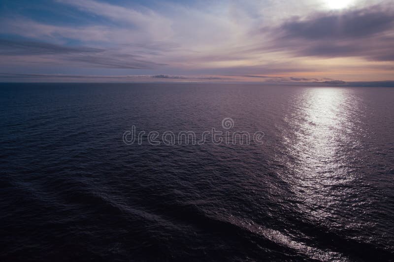 Purple Whisps of Clouds Above Calm Sea at Sunset Stock Image - Image of ...