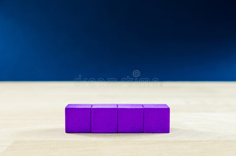 4 Purple Wooden Blocks Placed in a Row on a Solid Oak Table Stock Photo ...