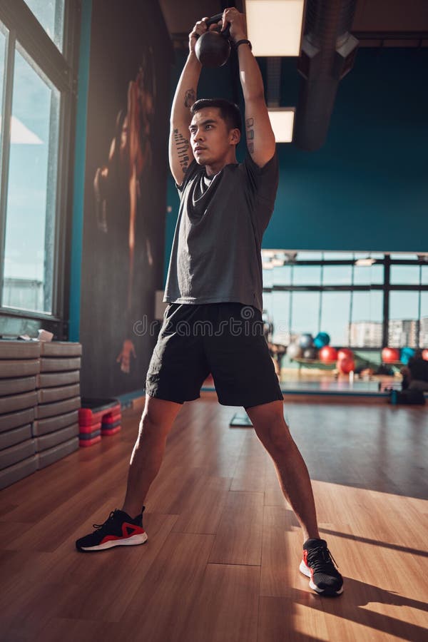 Put Everything into Each Workout. Shot of a Young Man Working Out Using ...