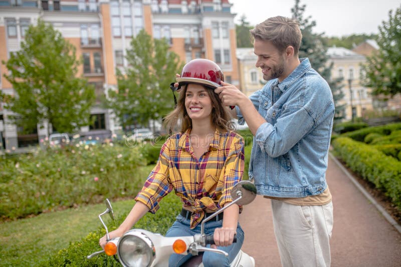 Man Putting on a Helmet on Womans Head Stock Image - Image of casual ...