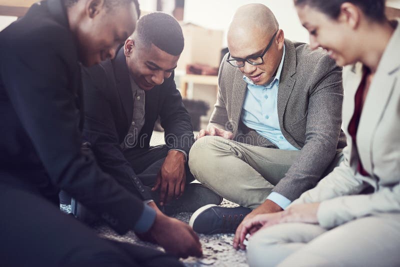 Putting it All Together. a Group of Coworkers Putting a Puzzle Together ...