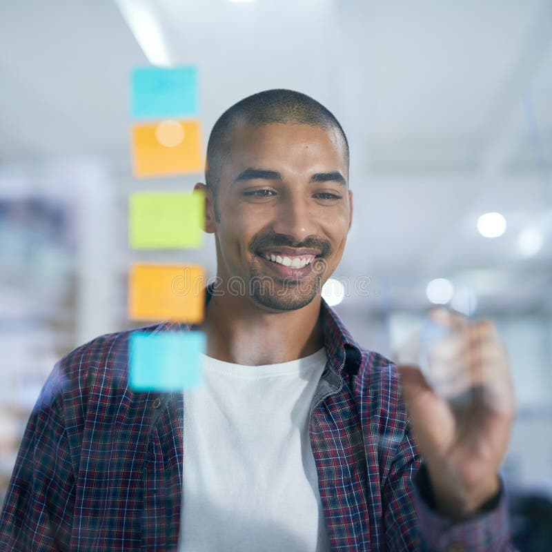 Putting His Ideas on the Board. a Young Designer Working on a Glass ...