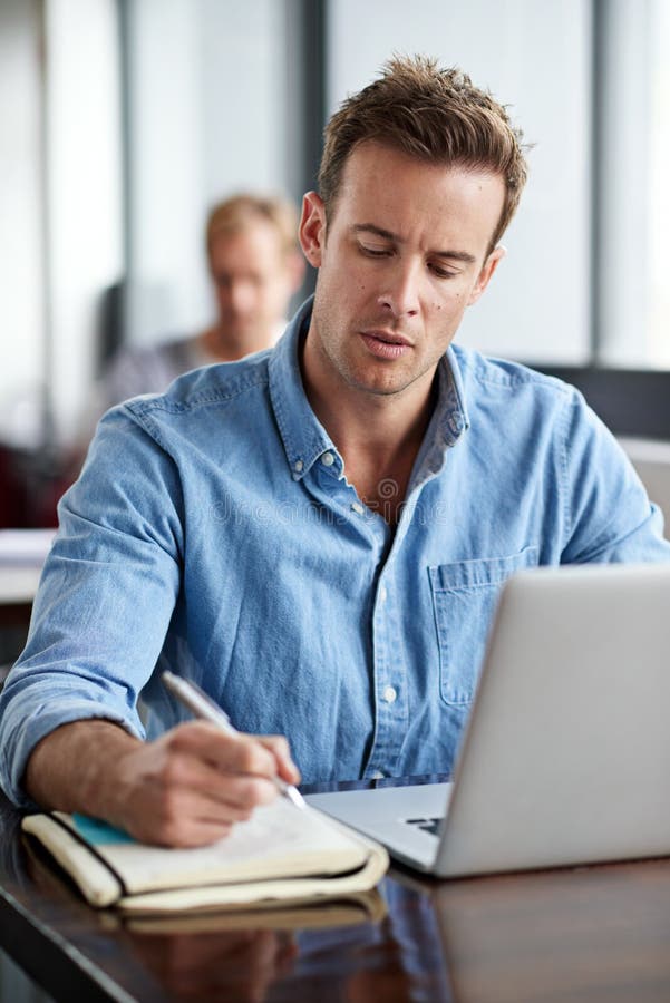 Putting His Plans into Action. a Man Writing Notes while Working on a ...