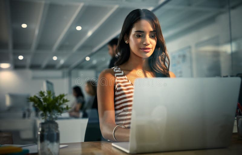 Putting in Hours of Hard Work. a Businesswoman Using a Laptop during a ...