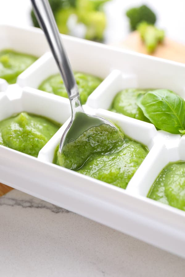 Putting Puree with Spoon into Ice Cube Tray on Table, Closeup. Ready ...