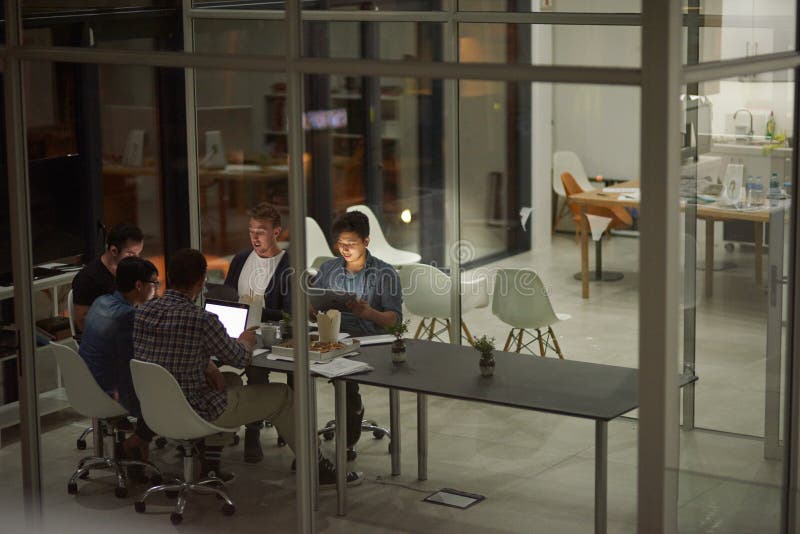 Putting in Some Extra Hours at Work. Shot of Employees Working in an ...